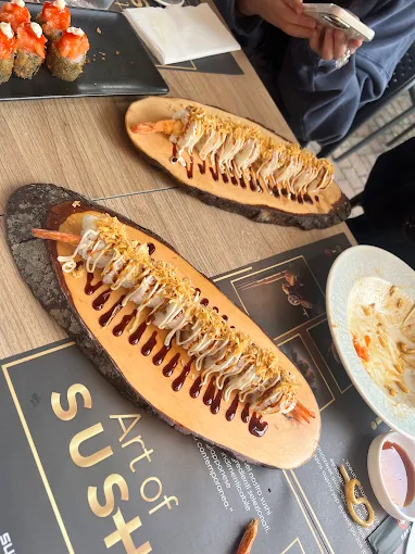 Roll di gambero con maionese e salsa teriyaki serviti su tagliere di legno